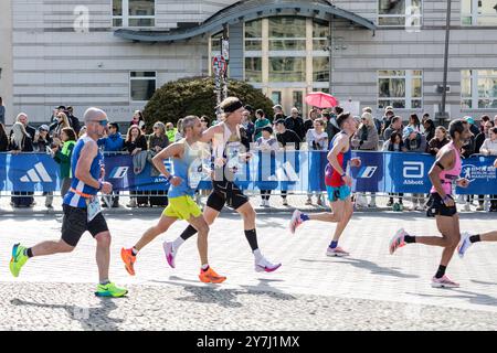 Marathon runners are seen close to the finish line running through the ...