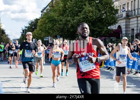 Marathon runners are seen close to the finish line running through the ...
