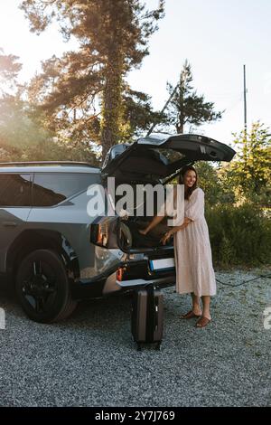 Smiling mature woman standing near bicycle ready to go on city ride ...