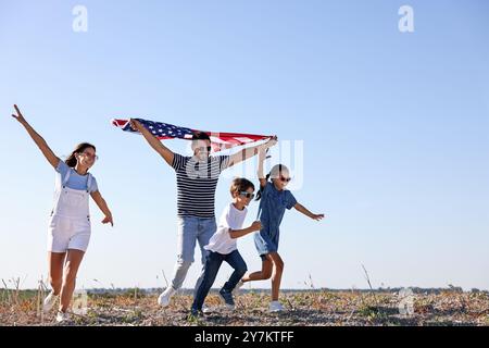Happy family running with flag of USA outdoors Stock Photo - Alamy