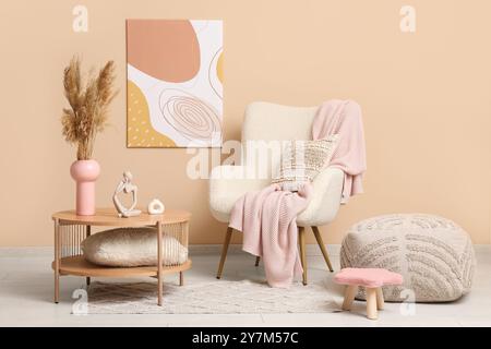 Comfortable armchair with soft pouf and table near white wall in living ...