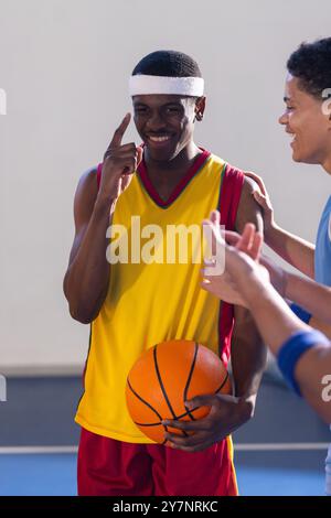 Talking with teammate, basketball player in locker room before game ...