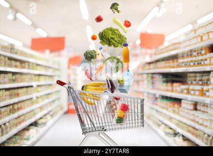 Groceries falling inside a shopping cart isolated on white background ...
