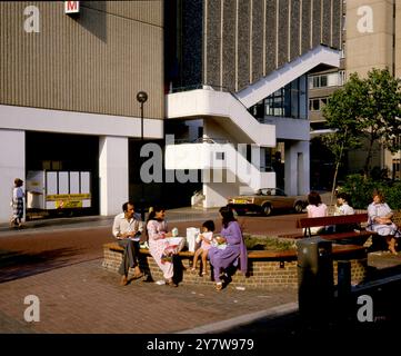 A family sitting in the sunshine in the semi pedestrianised High Street ...