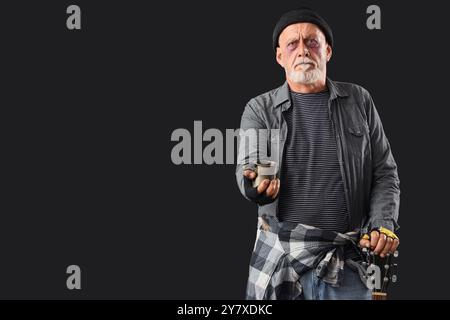 Mature homeless man with cup and guitar on black background. Banner for ...