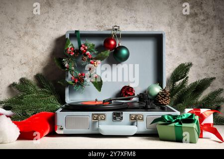 Vinyl record player with Christmas wreath, balls and gift boxes on ...