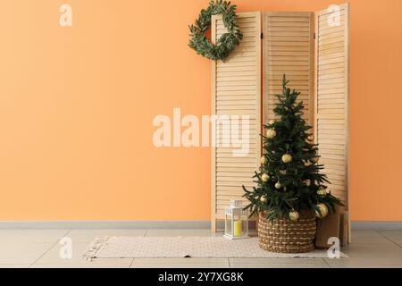 Folding screen and Christmas wreath near color wall, closeup Stock ...