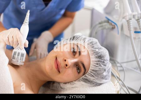 Female patient experiencing cryotherapy procedure on neck using ice ...