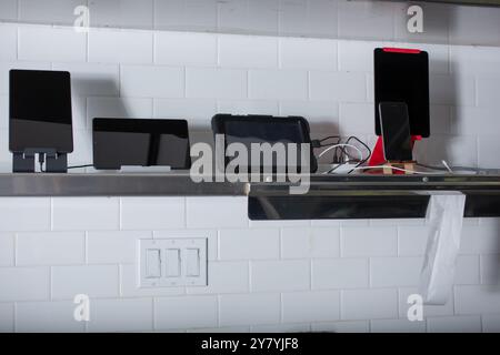 A view of several tablets used for food app deliveries, seen on a shelf ...