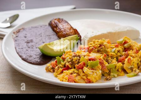 A view of a Latin American breakfast plate, featuring sunny side up ...