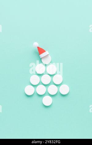 White tablets forming Christmas tree shape, red background, star tablet ...