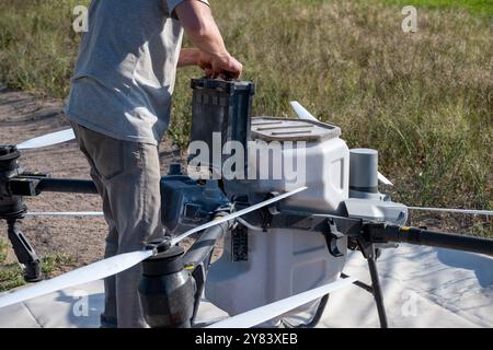 Operator replacing battery of agricultural drone Stock Photo - Alamy