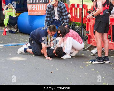 Exhausted half-marathon runner receiving first aid treatment at the ...