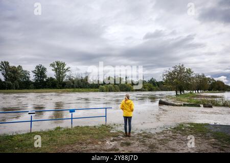 Flooded river. Worried woman looking at overflowing water during flood ...
