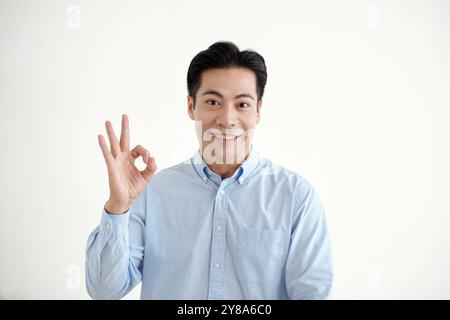 asian young man showing okay hand gesture with smiling Stock Photo - Alamy