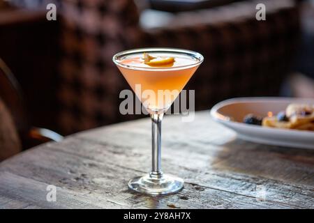 Gold colored cocktail in a martini glass with garnish Stock Photo - Alamy
