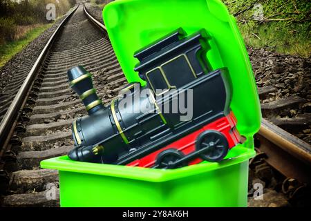 PHOTOMONTAGE, toy train in the trash can, symbolic photo of the railway ...