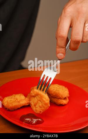 Chicken nuggets with ketchup. Holding chicken nuggets. Man eating ...