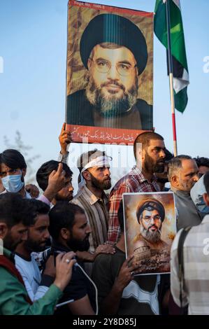 Kashmiri Shia Muslims listens to a religious speaker while holding ...