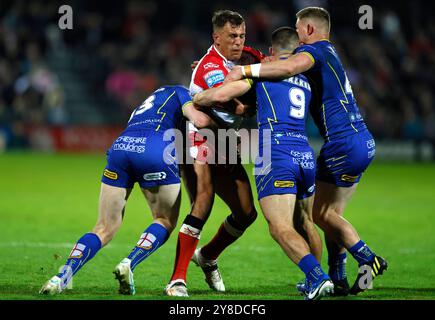 Warrington Wolves' Luke Yates (centre) is tackled by St Helens' Morgan ...