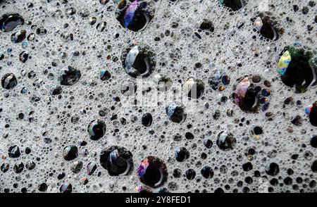 Macro view of bubbles forming on the water surface with blue background ...