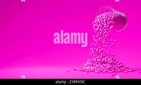 Pink plastic polypropylene granules pouring from the glass on a pink ...