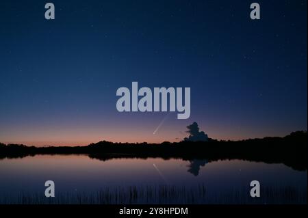 Comet Tsuchinshan-ATLAS rises in east over calm water of Nine Mile Pond ...