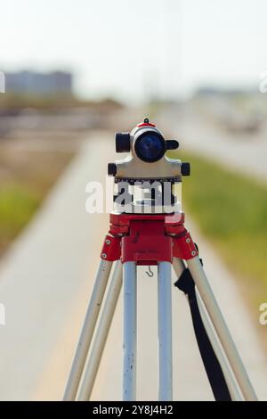 Geodetic equipment optical level mounted on tripod at construction site ...