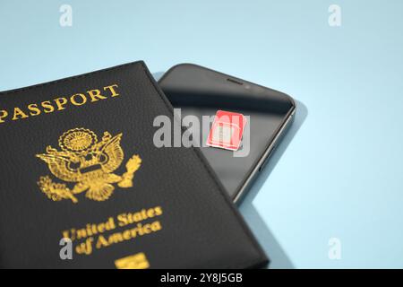 Modern SIM card, smartphone and passport on light blue background, top ...