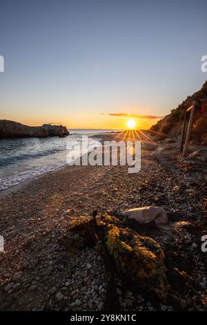 Hidden cove at sunrise. View of the fine pebble beach in the morning ...