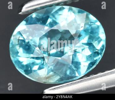 Natural gemstone blue aquamarine in tongs on a background Stock Photo ...