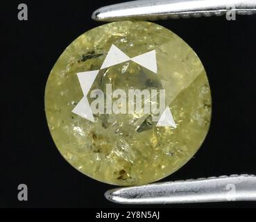 Natural gemstone yellow citrine in tweezers on a gray background Stock ...