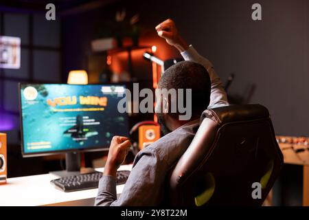 Ecstatic gamer playing intense classic arcade spaceship racing ...
