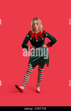 Emotional young woman dressed as elf on red background Stock Photo - Alamy