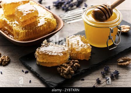 Honeycomb on slate tray with honey and nuts on kitchen table Stock ...