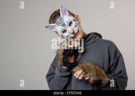 portrait of a teenager quadrobics in a cat mask on a white background ...