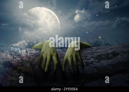Two witch hands reaching out from behind brick wall on dark background ...