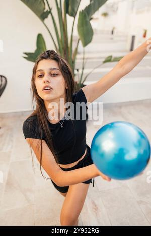 Dynamic Fitness Pose Featuring a Blue Ball for Enhanced Exercise ...