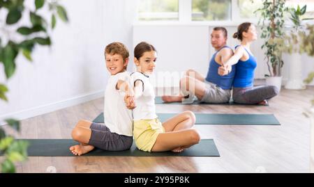 Family practicing yoga in pairs at studio Stock Photo - Alamy