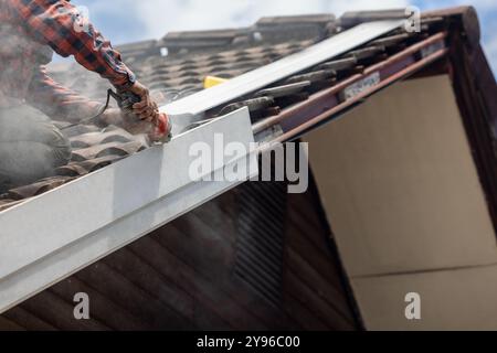 Handyman replace roof eaves with artificial wood Stock Photo - Alamy