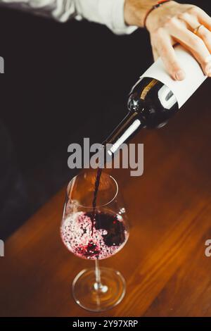 An overhead photo of a glass of red wine with a vintage corkscrew and a ...