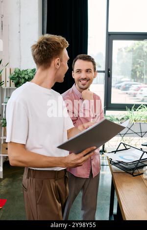 Two men engaging in conversation at reception desk, one holding ...