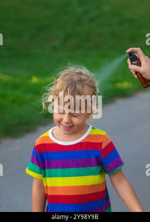 Child spraying mosquito repellent. Selective focus. kid Stock Photo - Alamy