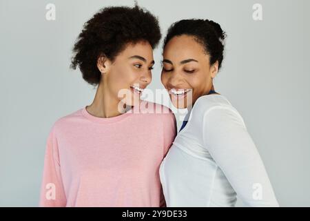 Two women express joy and warmth, showcasing their bond and beauty in a ...