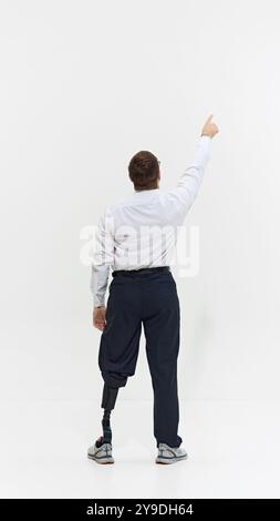 Man with prosthetic leg pointing upwards, symbolizing ambition and ...