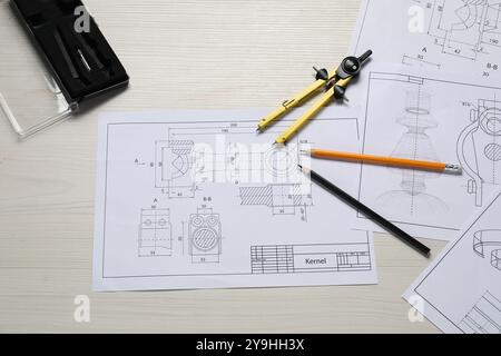 Different engineering drawings, pencils and divider on wooden table ...