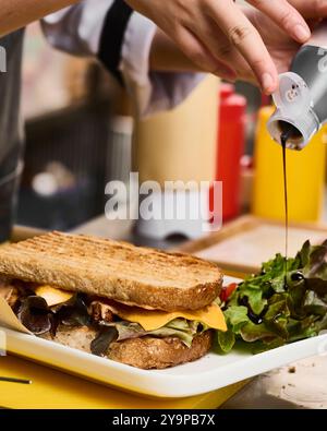 Chef making sandwich in rustic style with bacon and fresh vegetables ...