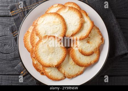 French delicacy pastry tuile with almond on wood background Stock Photo ...