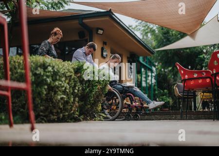 Boy with Down syndrome pushing girl in wheelchair outdoors Stock Photo ...