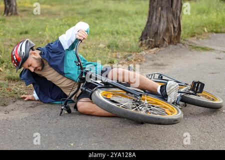 Young man fallen off his bike and lying on grass outdoors Stock Photo ...